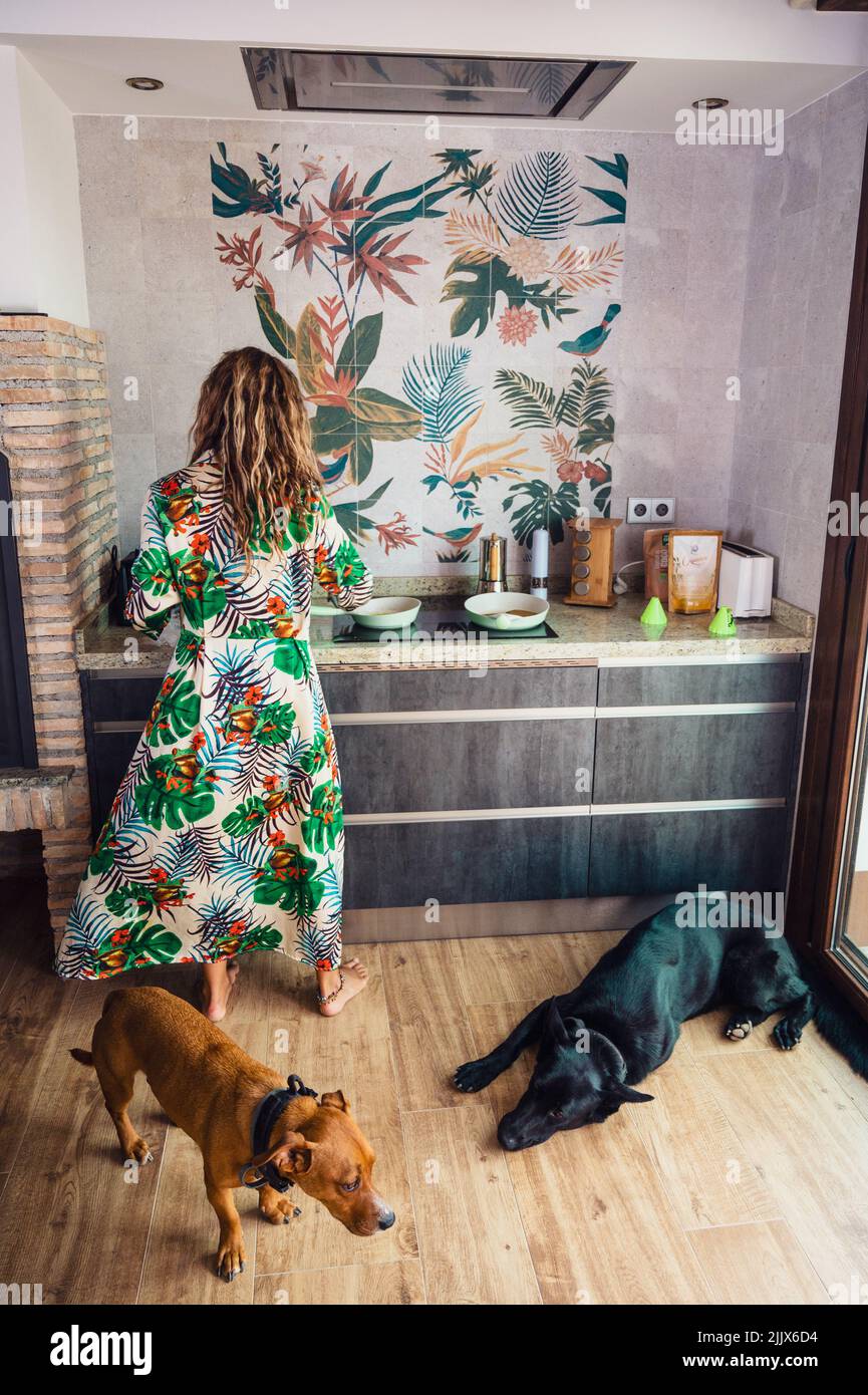 High angle of loyal dog resting on floor near barefoot Woman in ...