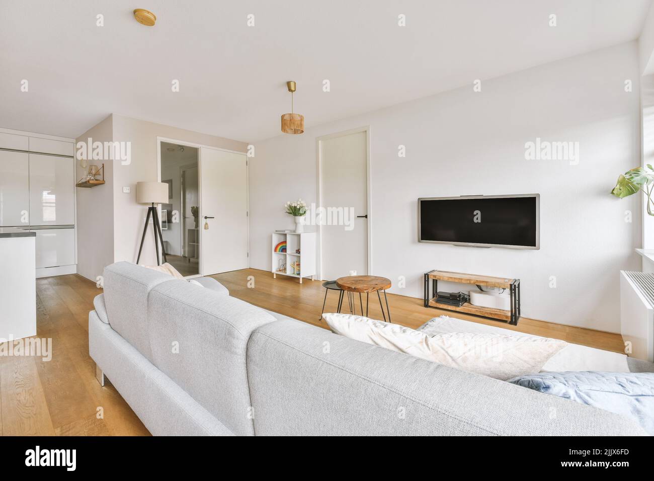 Contemporary open plan kitchen with dining table set and gray sofa in ...