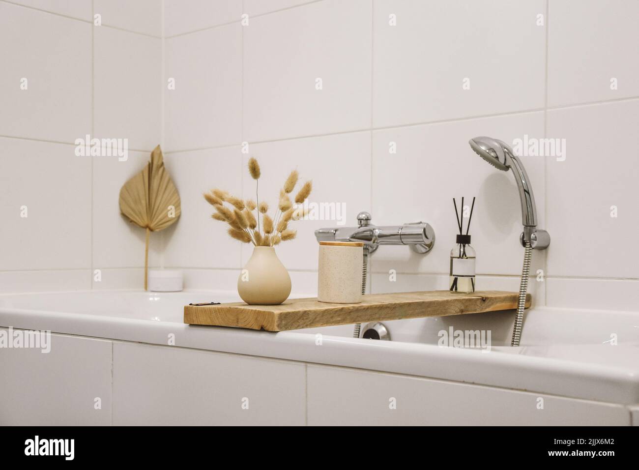 From below bathtub with bathroom utensils on white tiled wall Stock ...