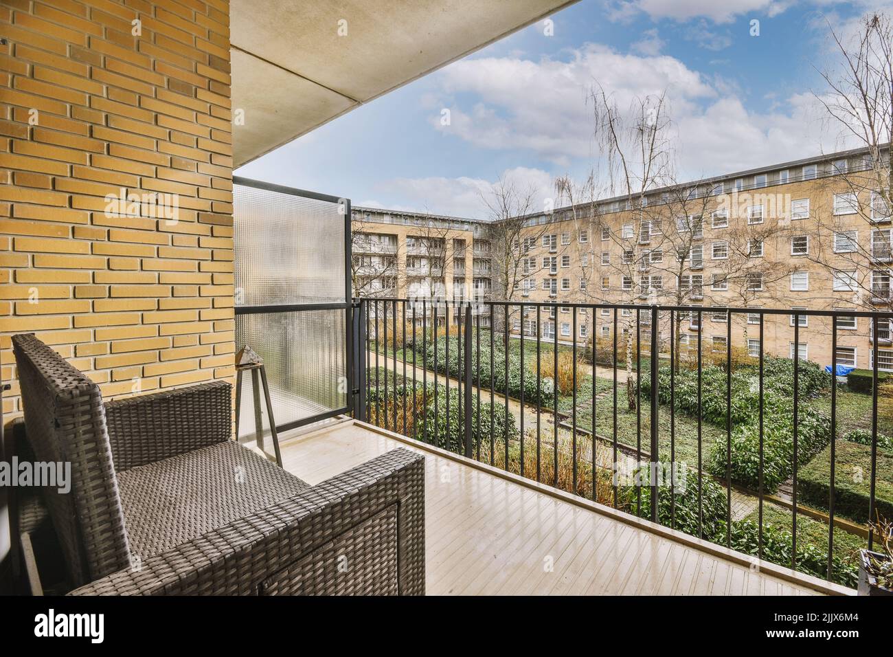 Brick balcony with metal railings, wooden chair Stock Photo - Alamy