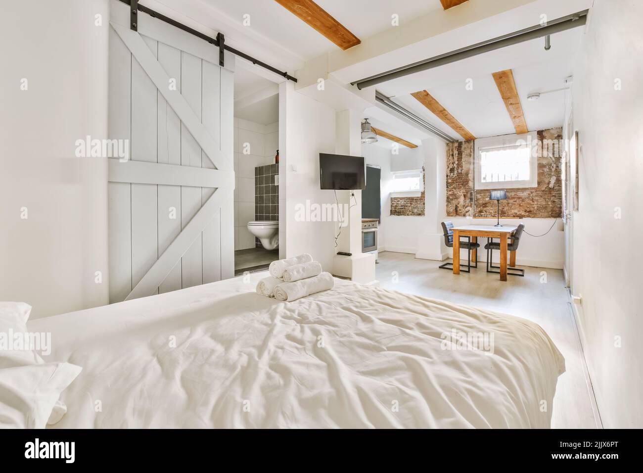 Interior of modern home with bed next to a table and chairs under ...