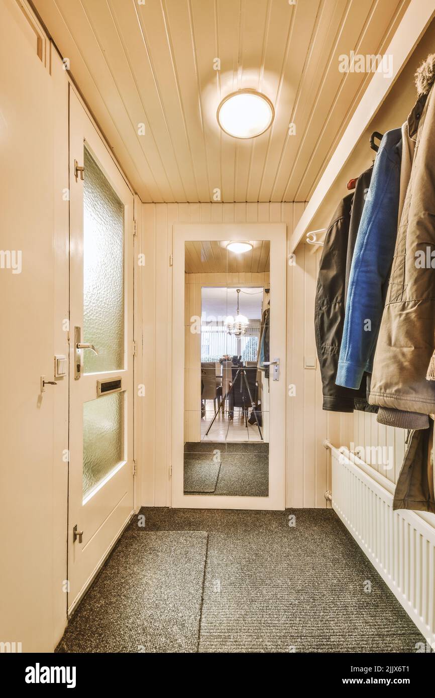 Interior passage way with mirror on door in modern house Stock Photo ...