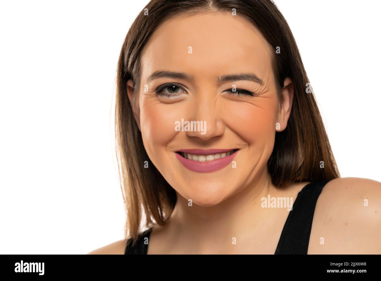 portrait of a young beautiful smiling winking woman with blue eyes and ...