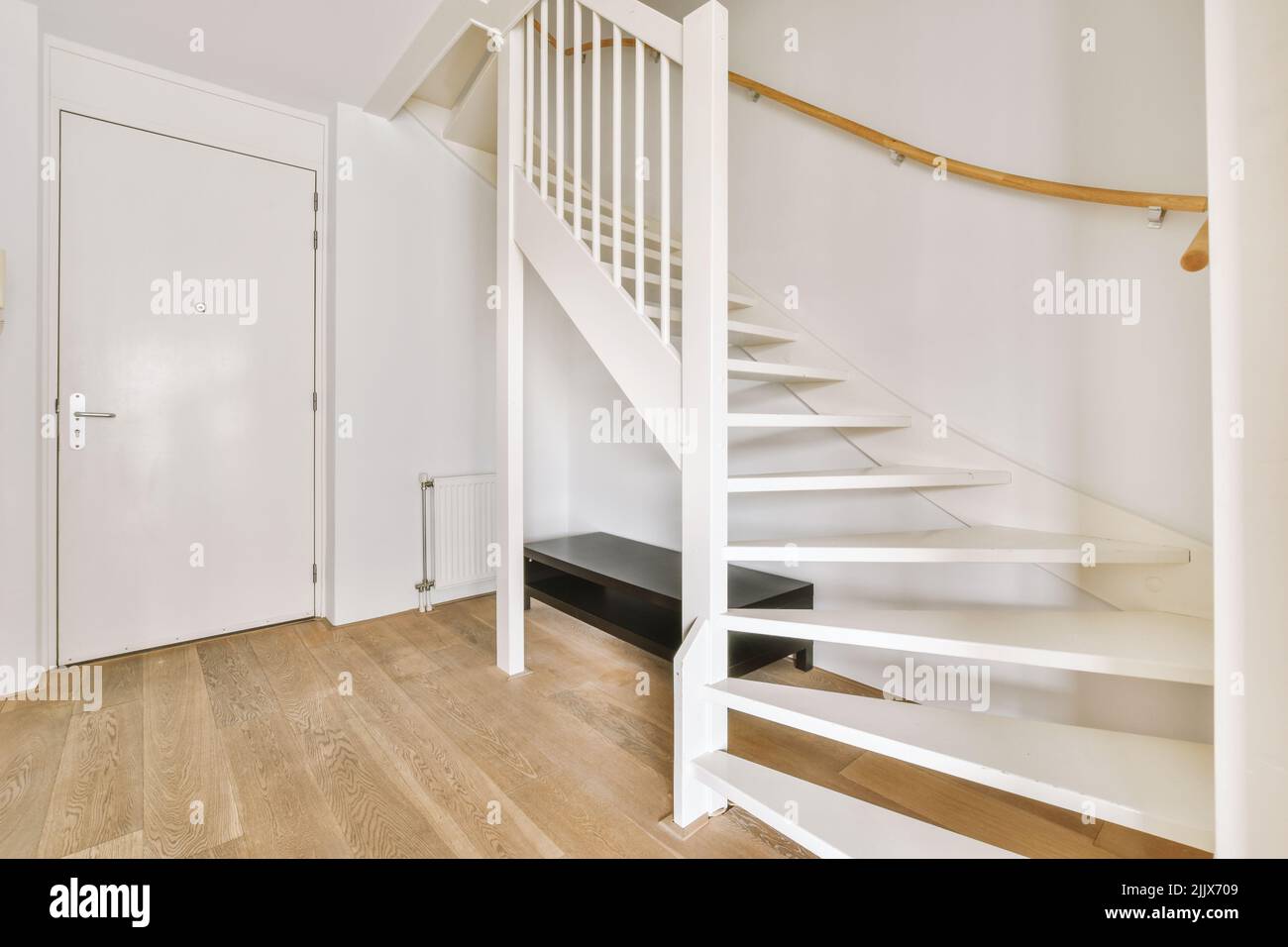 Staircase in light hallway with white floor and walls on sunny day in modern house Stock Photo ...