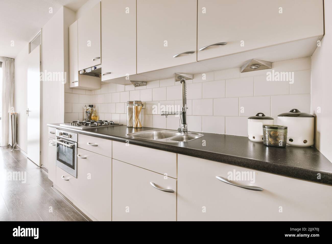 Counter with sink placed in modern kitchen with white cabinets and ...