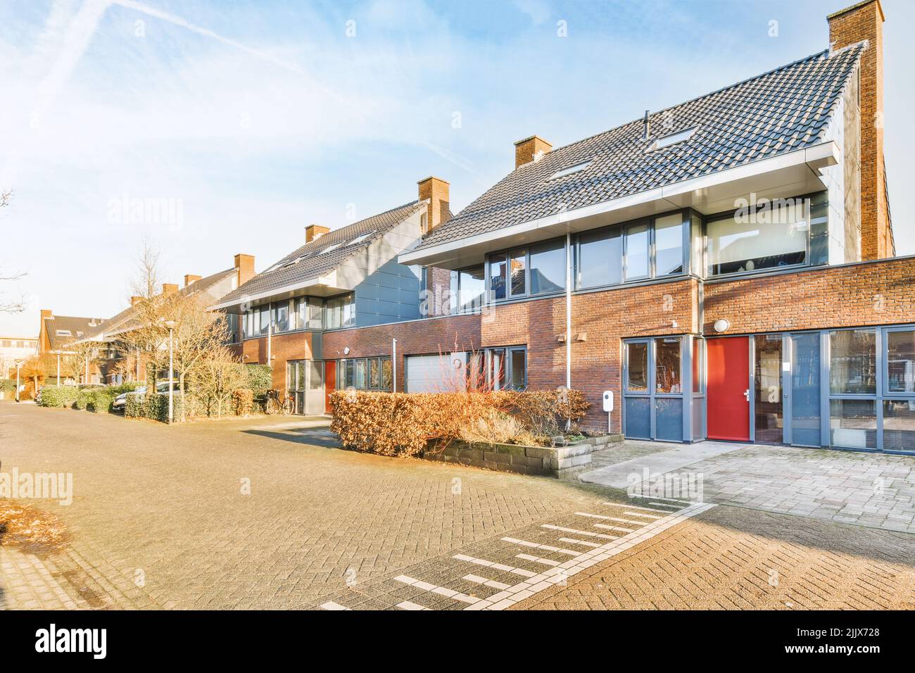 View of a street with houses lined up under a blue sky with clouds ...