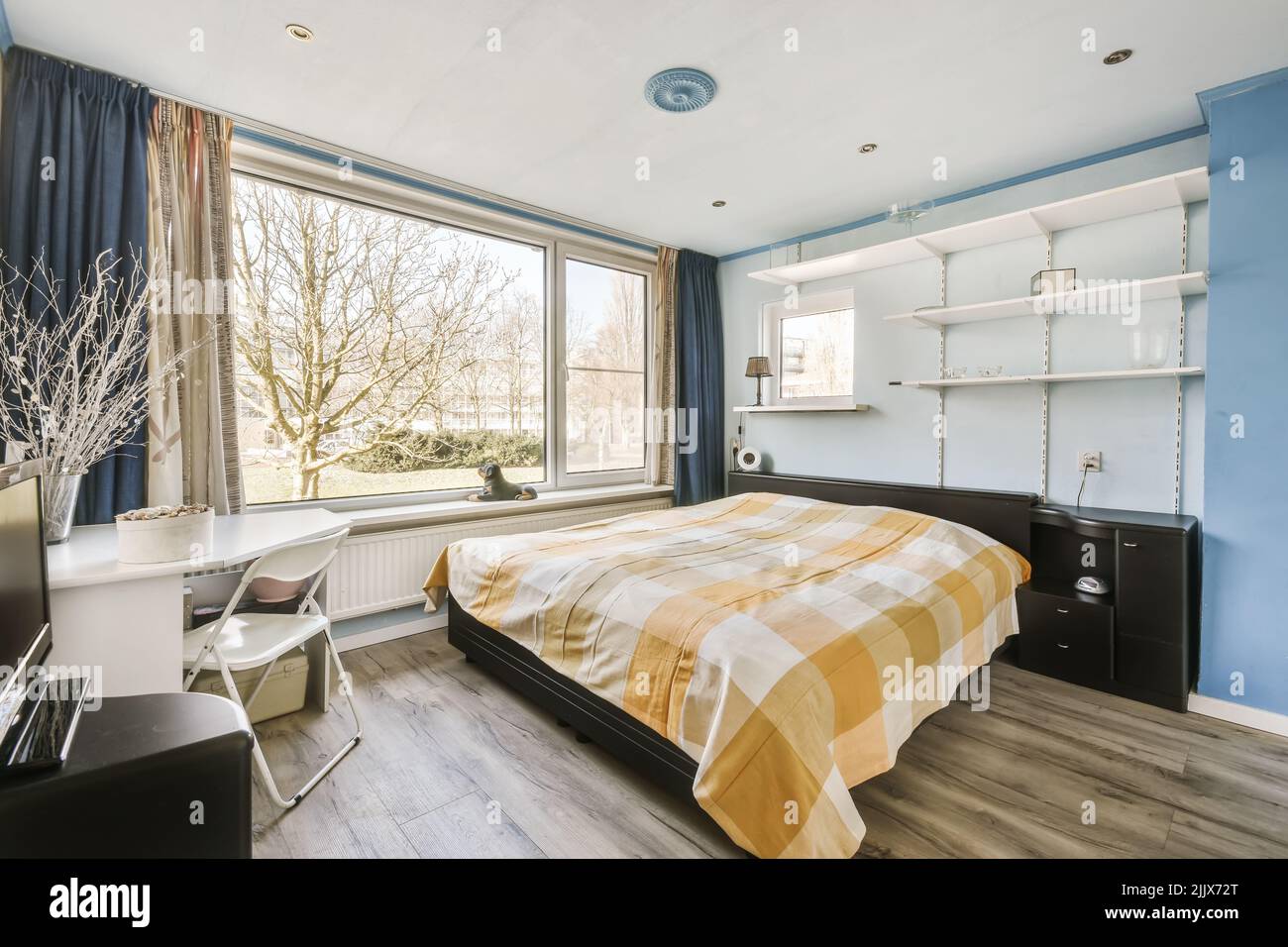 Table desk with modern computer placed in light spacious bedroom with ...