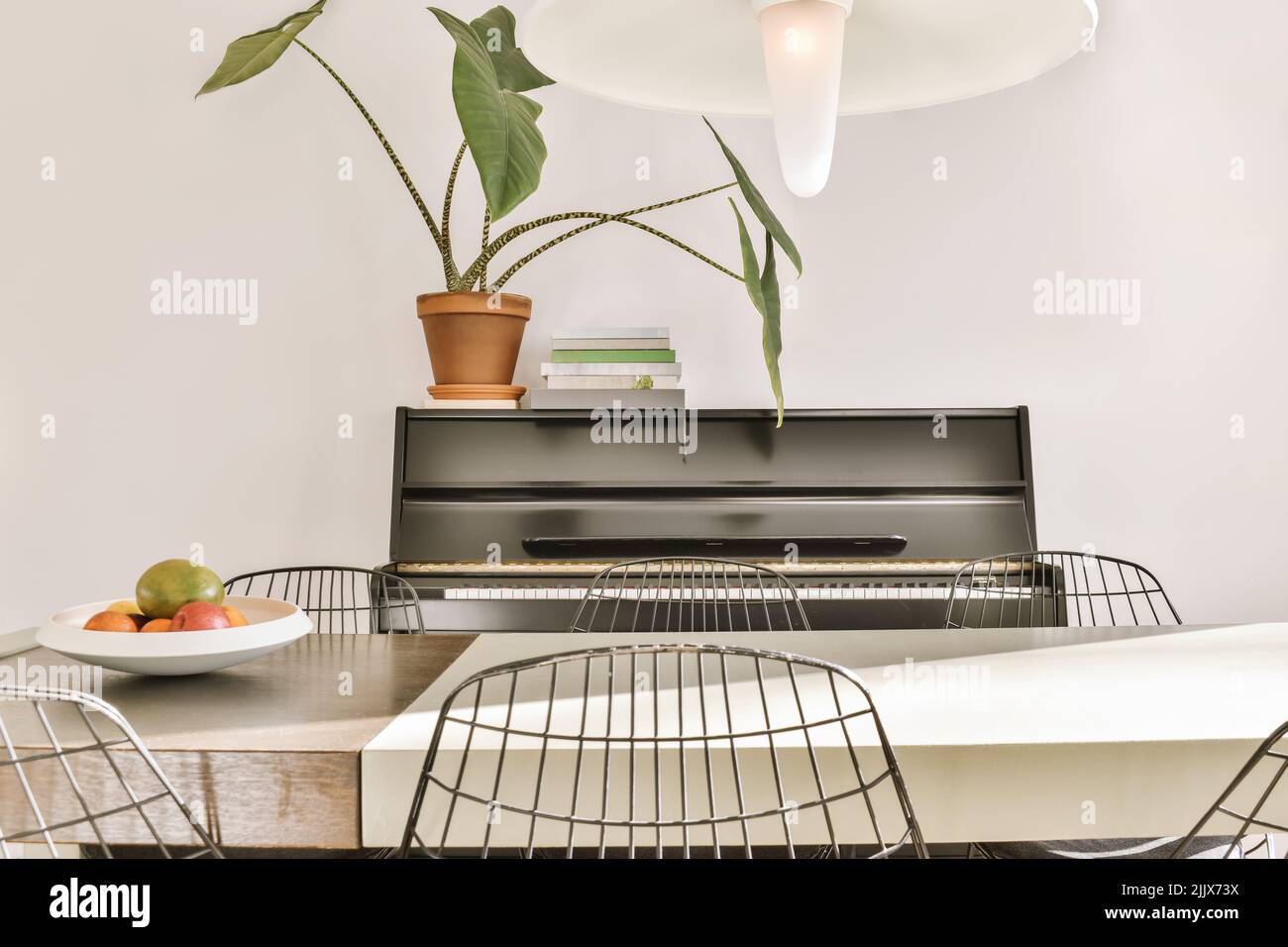 Interior of modern home with table and chairs next to a piano leaning ...