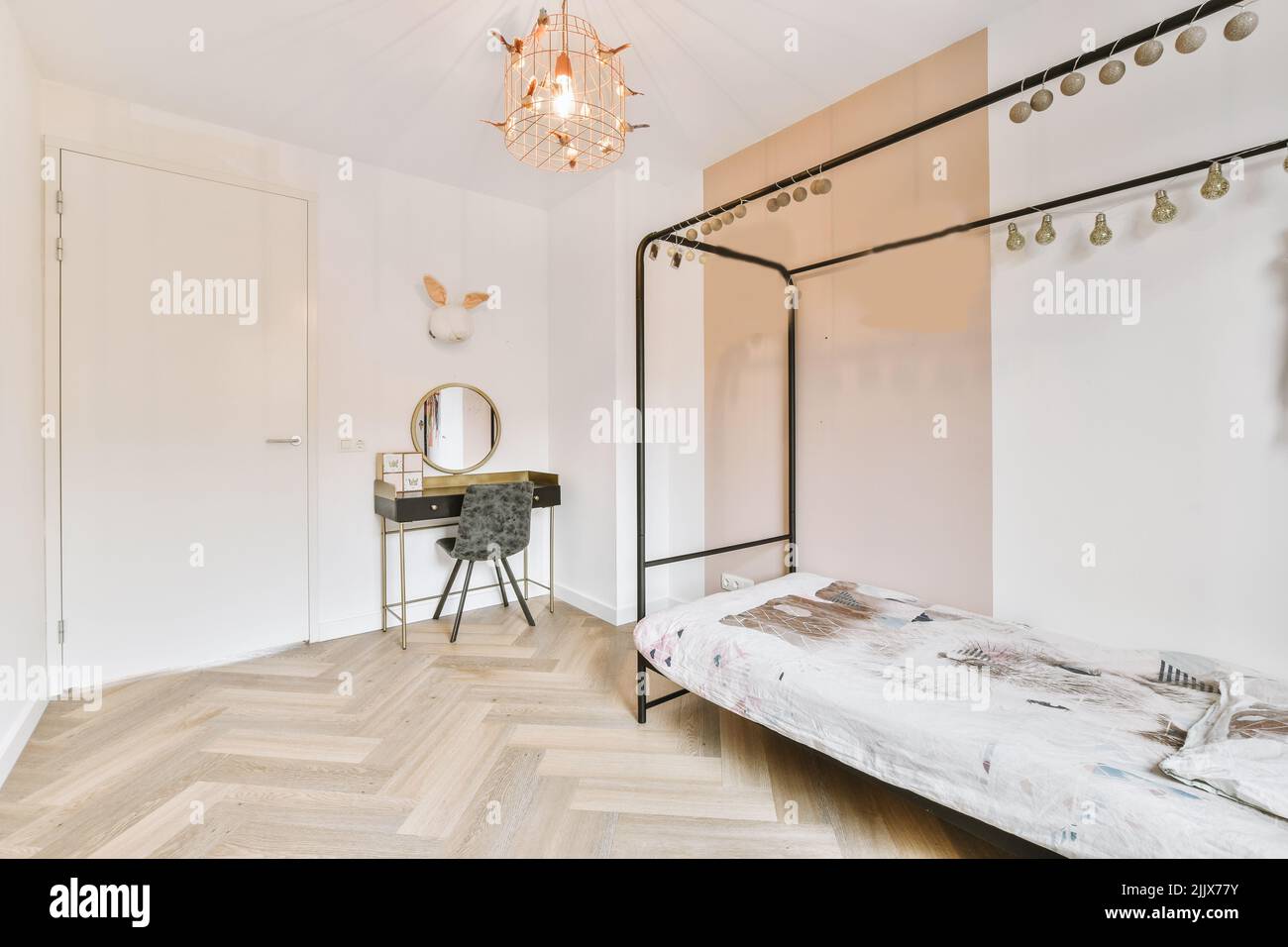 Comfortable bed with white walls next to a desk under bright lamp Stock ...