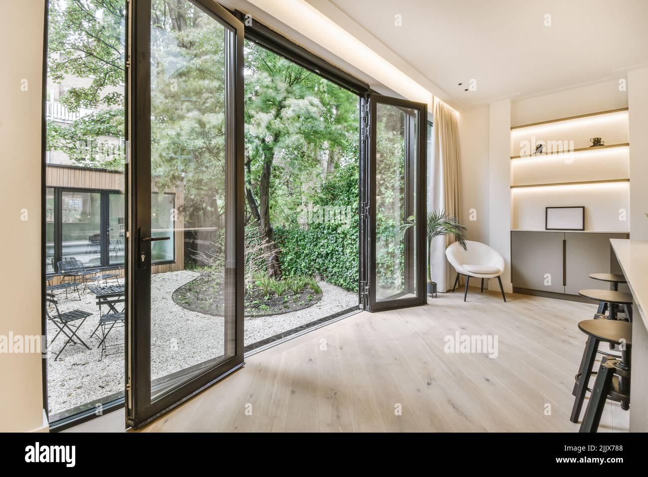 Backyard seen through modern kitchen window Stock Photo - Alamy