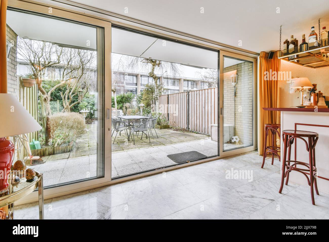 Bar counter and dining room next to bright windows showing a backyard ...