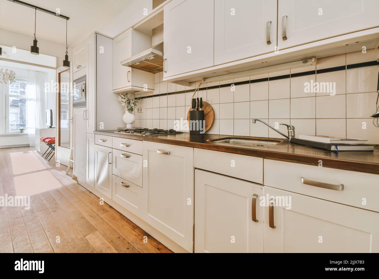 Counter with white cupboards and sink placed in light kitchen in ...