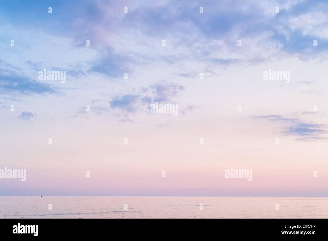 Picturesque view of pink and blue cloudy sky located over rippling sea ...