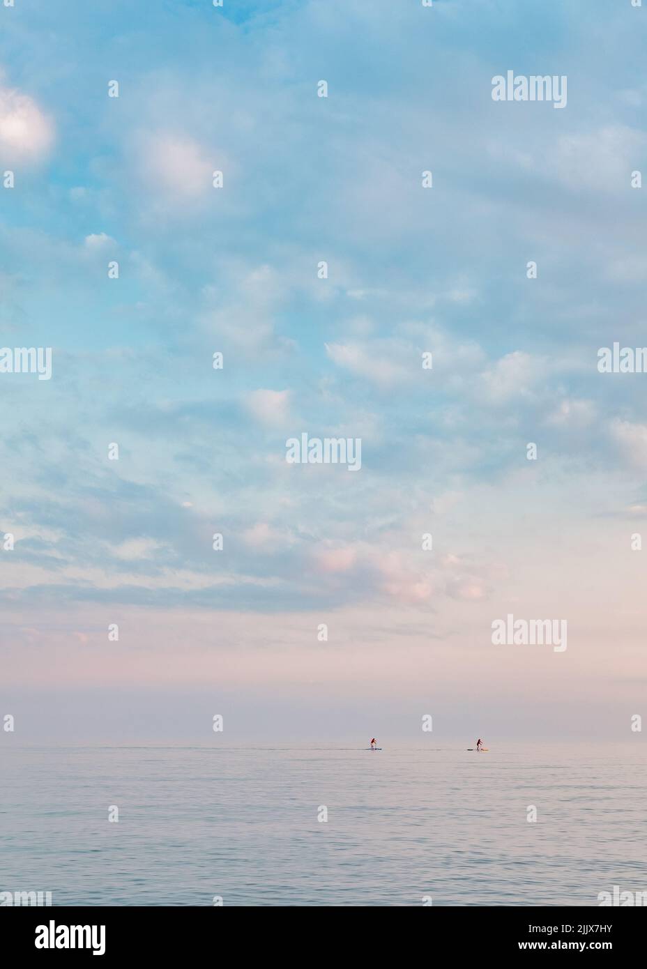 Picturesque view of pink and blue cloudy sky located over rippling sea ...