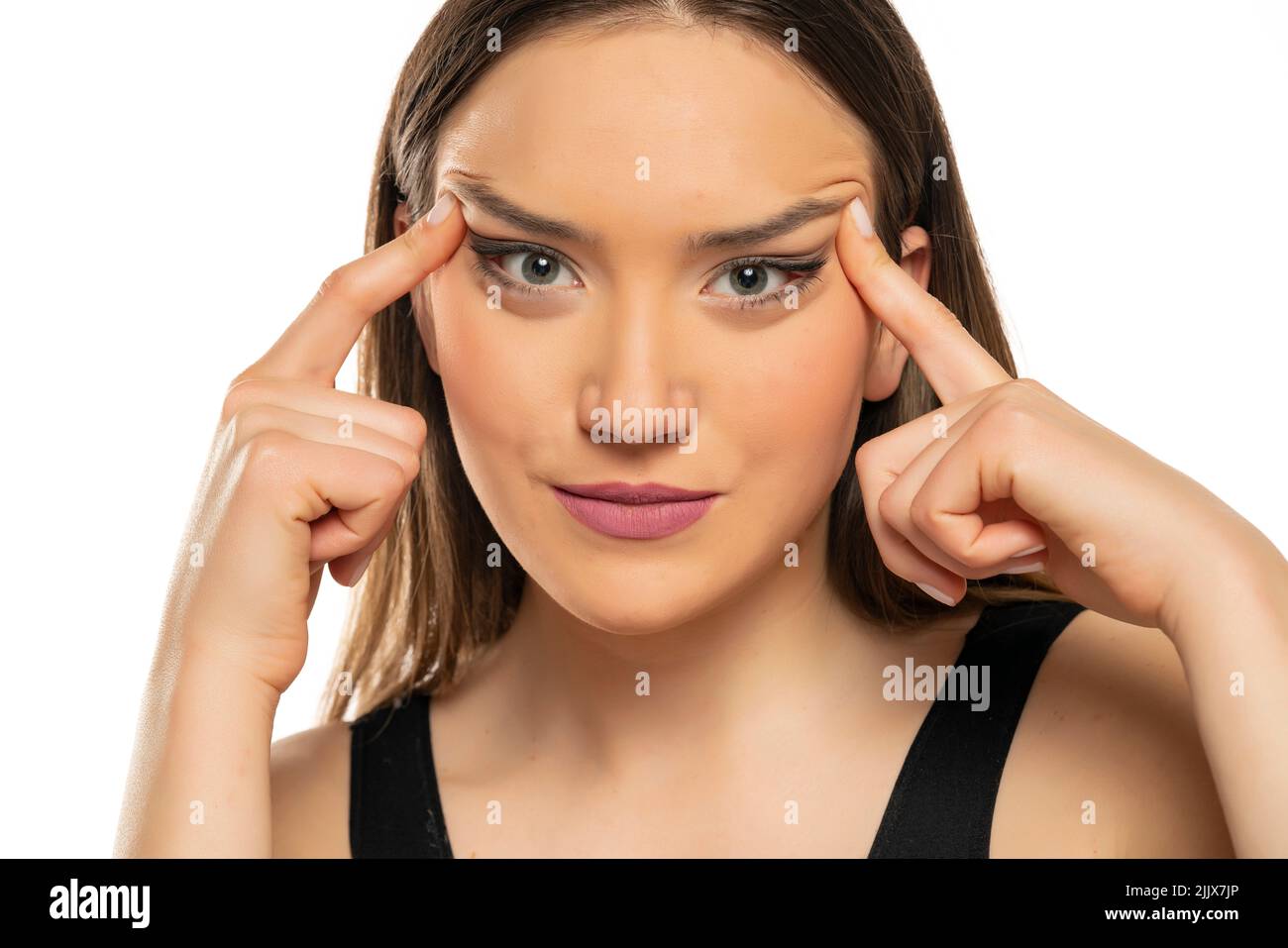 young woman pulling her eyes on a white background Stock Photo - Alamy