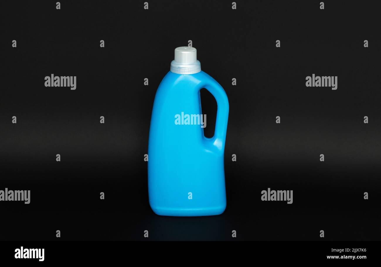Blue plastic bottle with a grey cap isolated on black background for ...