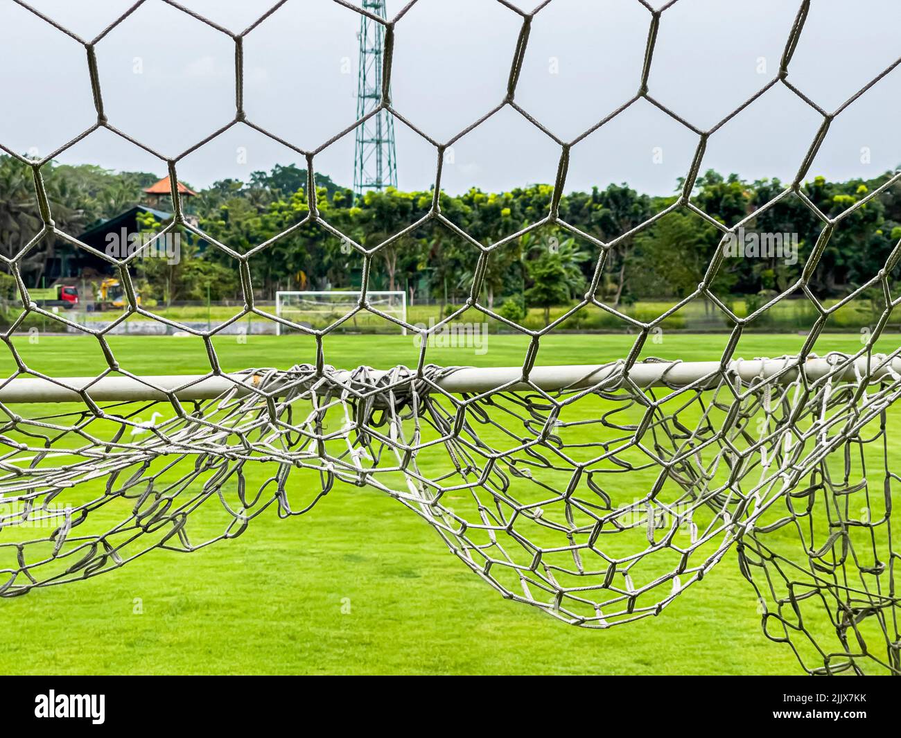 View through ootball gates net to large football field with green lawn ...