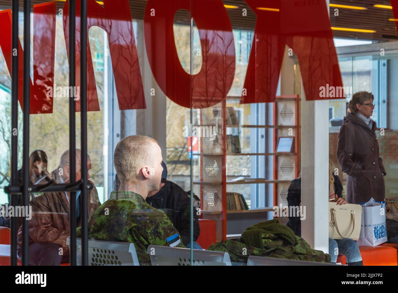 Young soldier sitting behind a glass window at Tallinn bussijaam bus ...