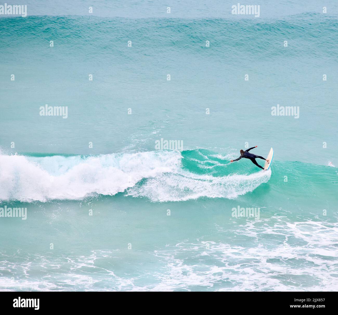 A surfer rides a wave on the Atlantic sea at the Great Western beach at ...