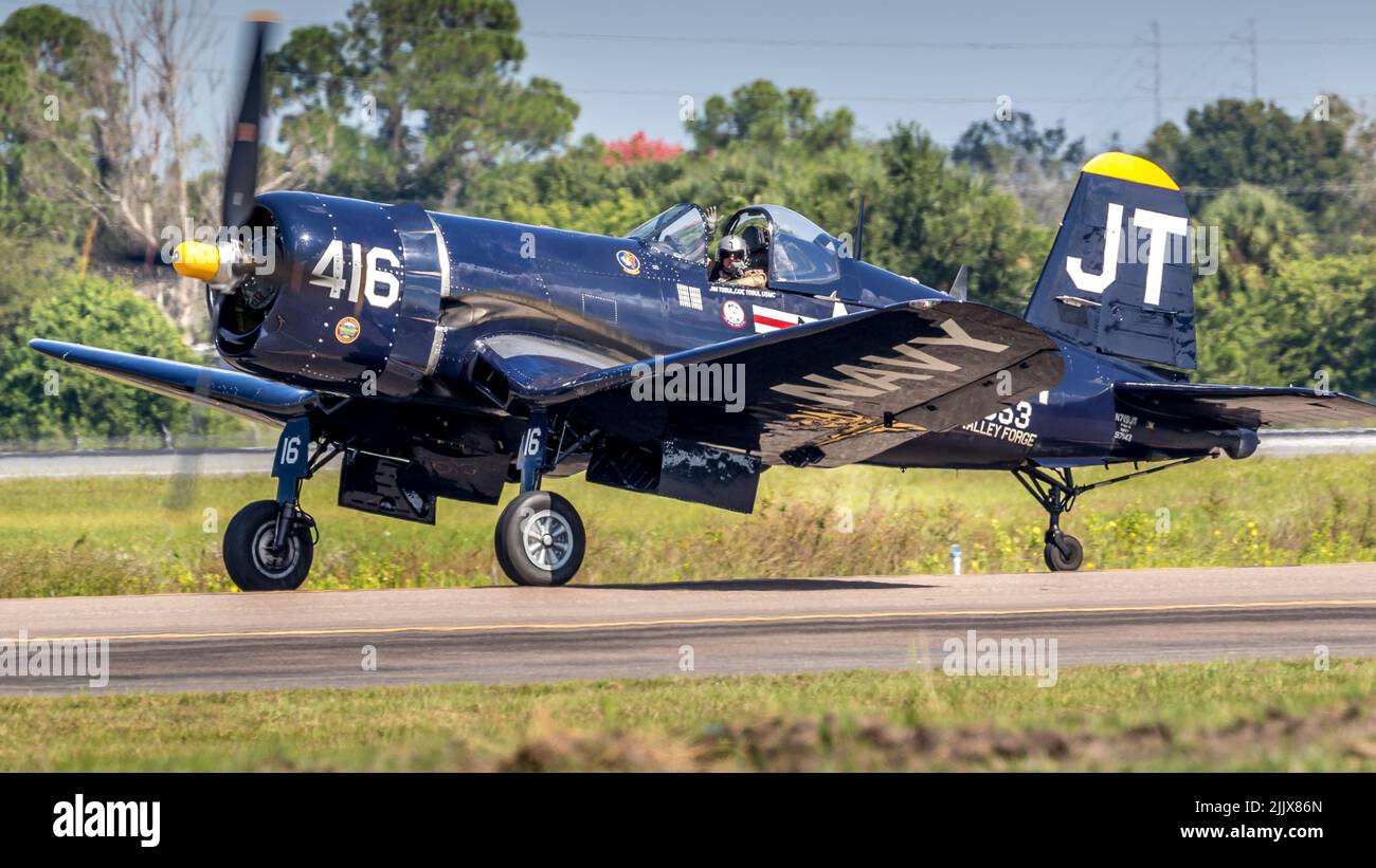 The pilot sitting in the blue jet aircraft on a sunny day outdoors ...