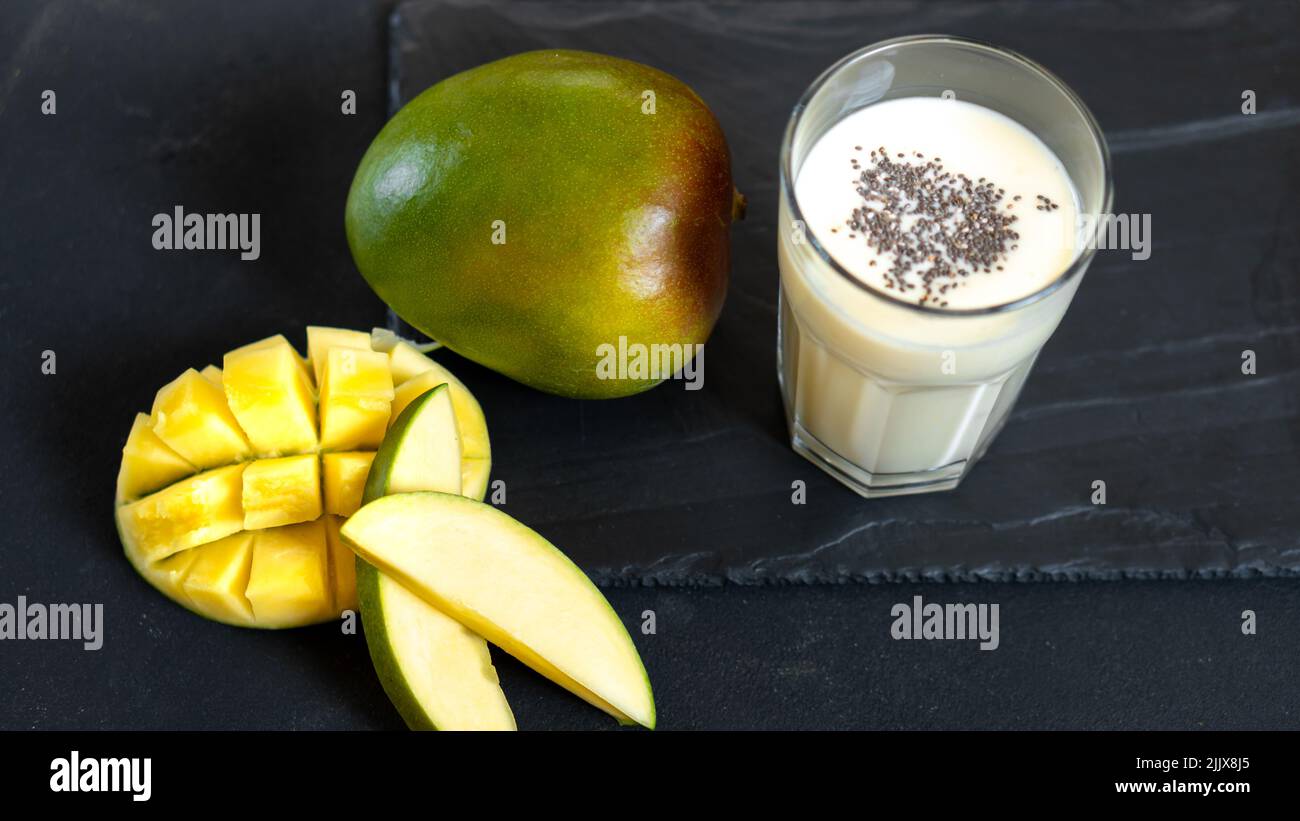 Milk drink on black background with mango. A classic mango milkshake ...
