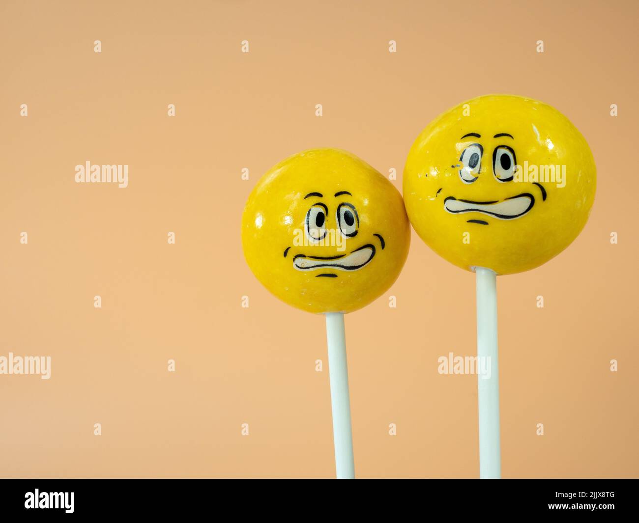 Yellow lollipops. Lollipops with a painted face. Lollipops close-up ...
