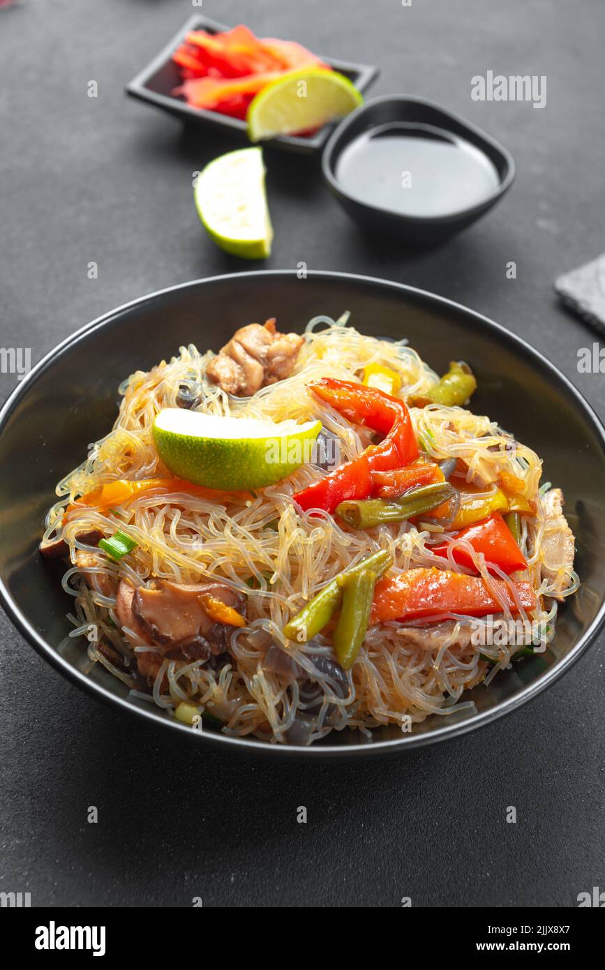 Glass noodle with vegetable in a black bowl on a grey background. Asian ...