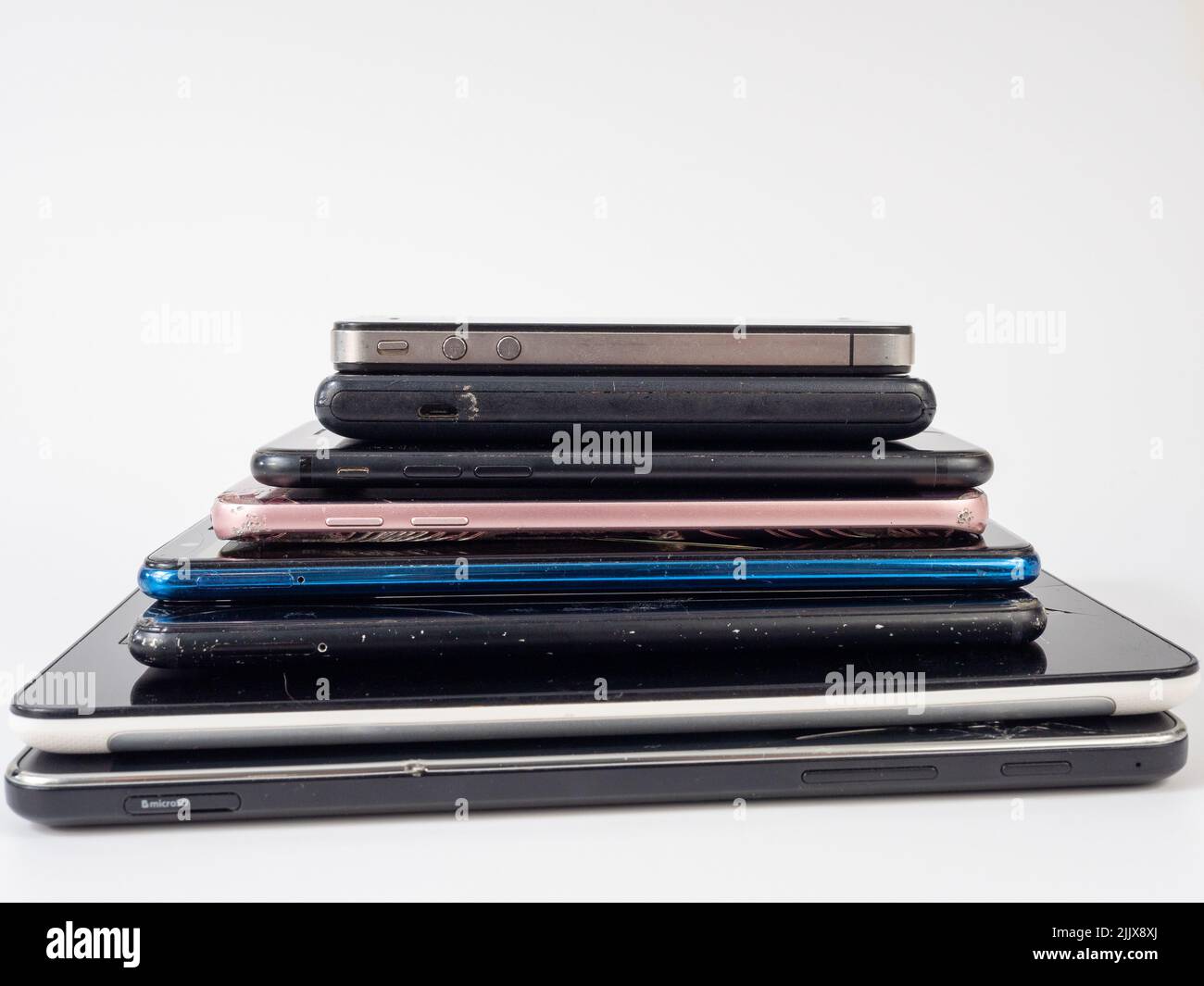 Old smartphones lie on top of each other. Stack of old mobile phones ...