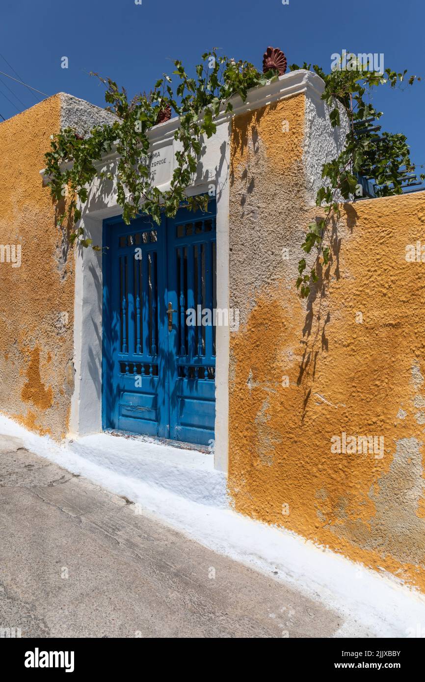 Traditional Greek bright blue door against an orange wall in Akrotiri ...