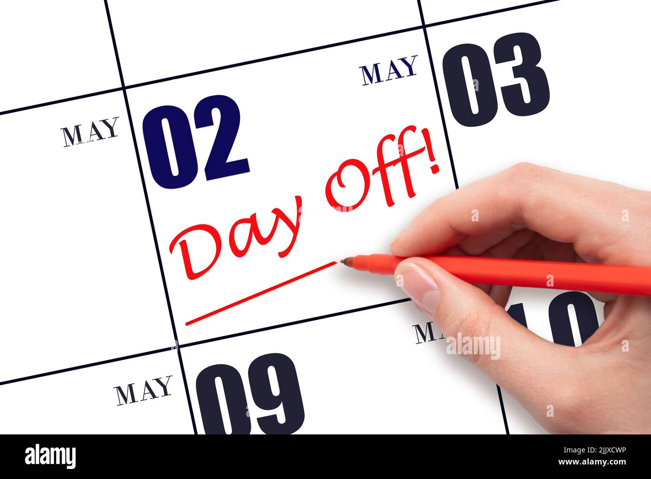 2nd day of May. Hand writing text DAY OFF and drawing a line on ...