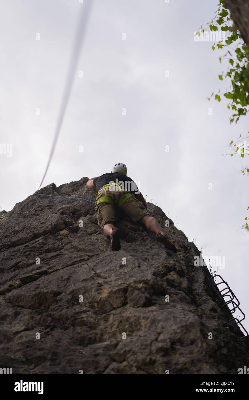 Handsome and fit guy is climbing while reaching the top of the hill ...