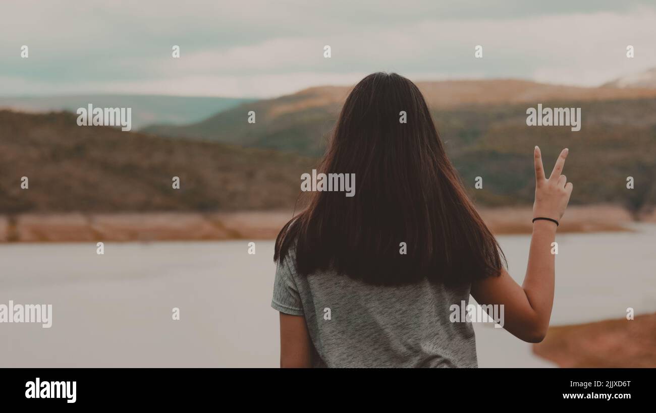teenager girl from the back making peace sign outside Stock Photo - Alamy