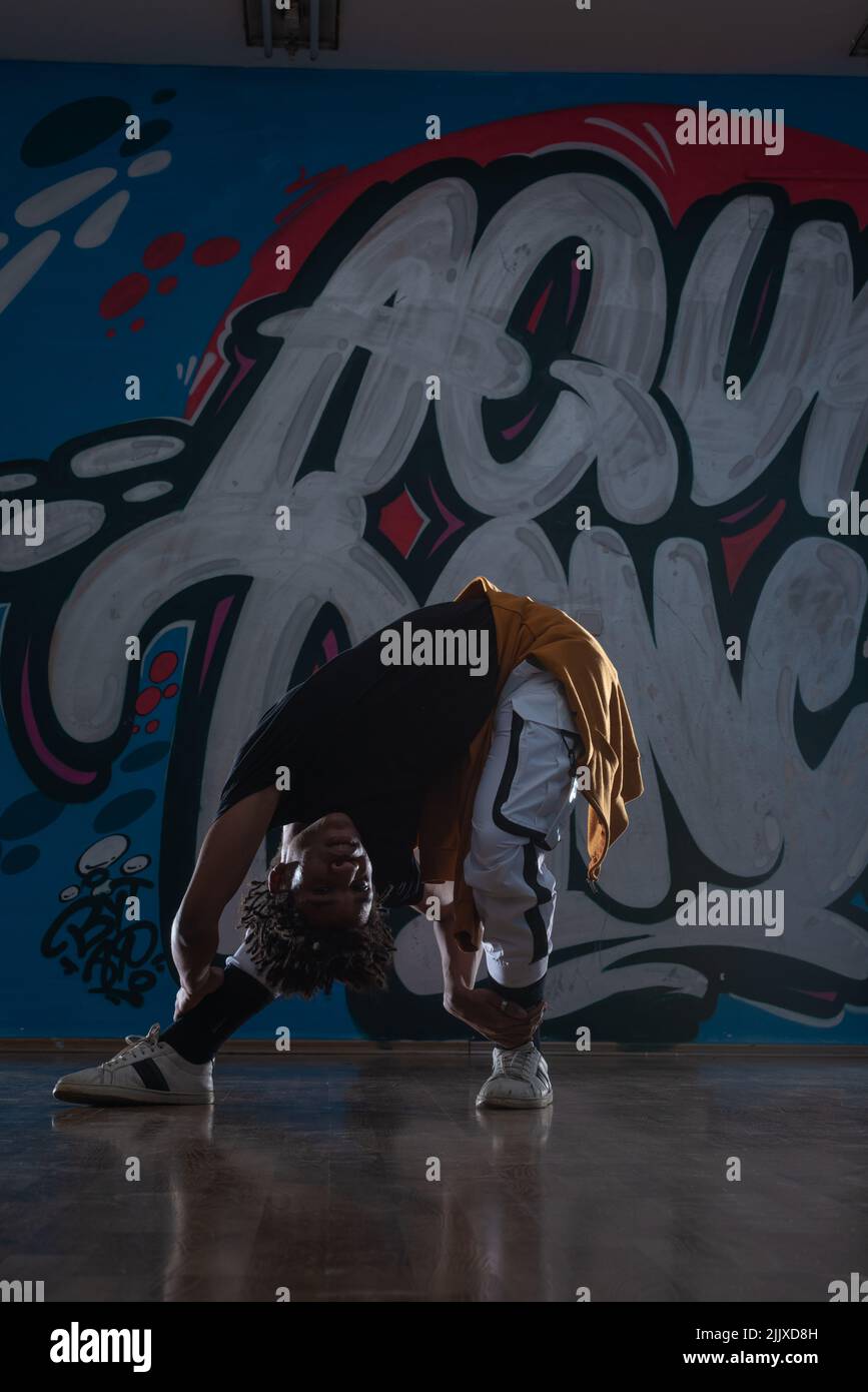 African American hip hop dancer (breakdancer) performing over graffiti ...