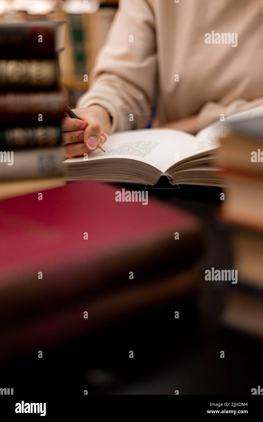 Details of girl taking notes in a library Stock Photo - Alamy