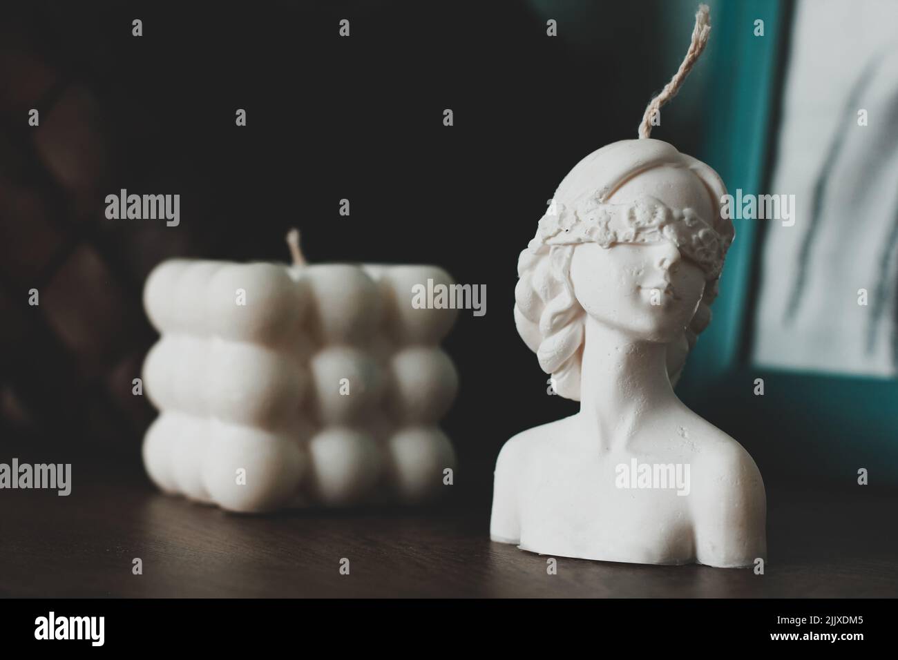 Decorative candle in a dark interior. Candle in the form of a bust of a ...