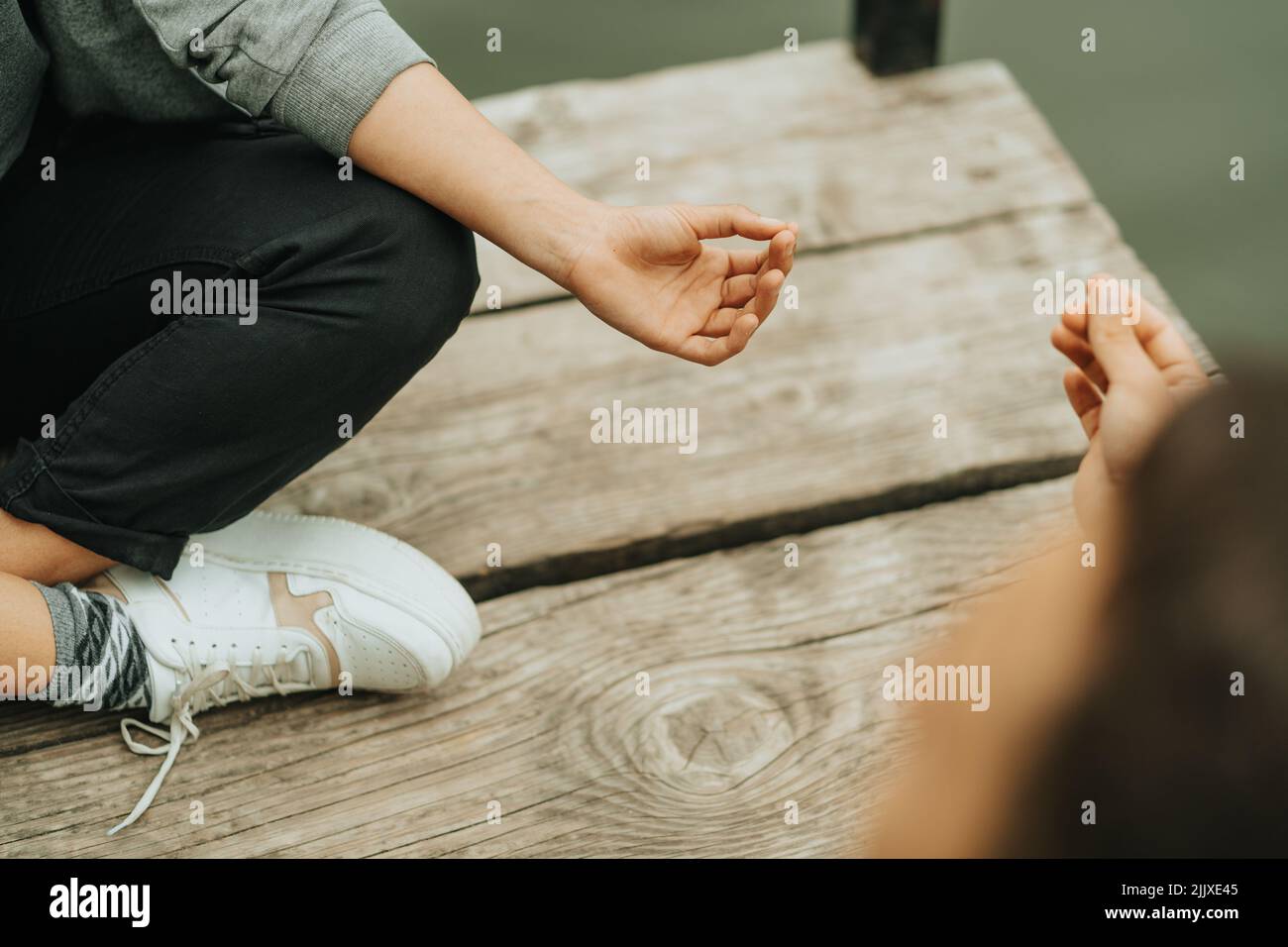 Details of two hands of couple meditating together on the lake Stock ...
