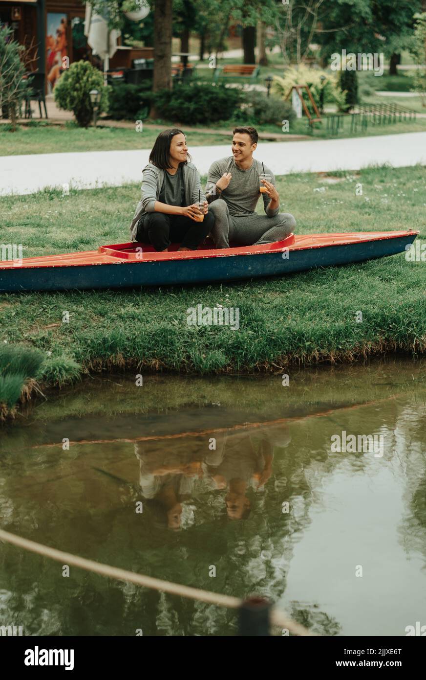 Amazing couple smiling while sitting on a red kayak in the park Stock ...