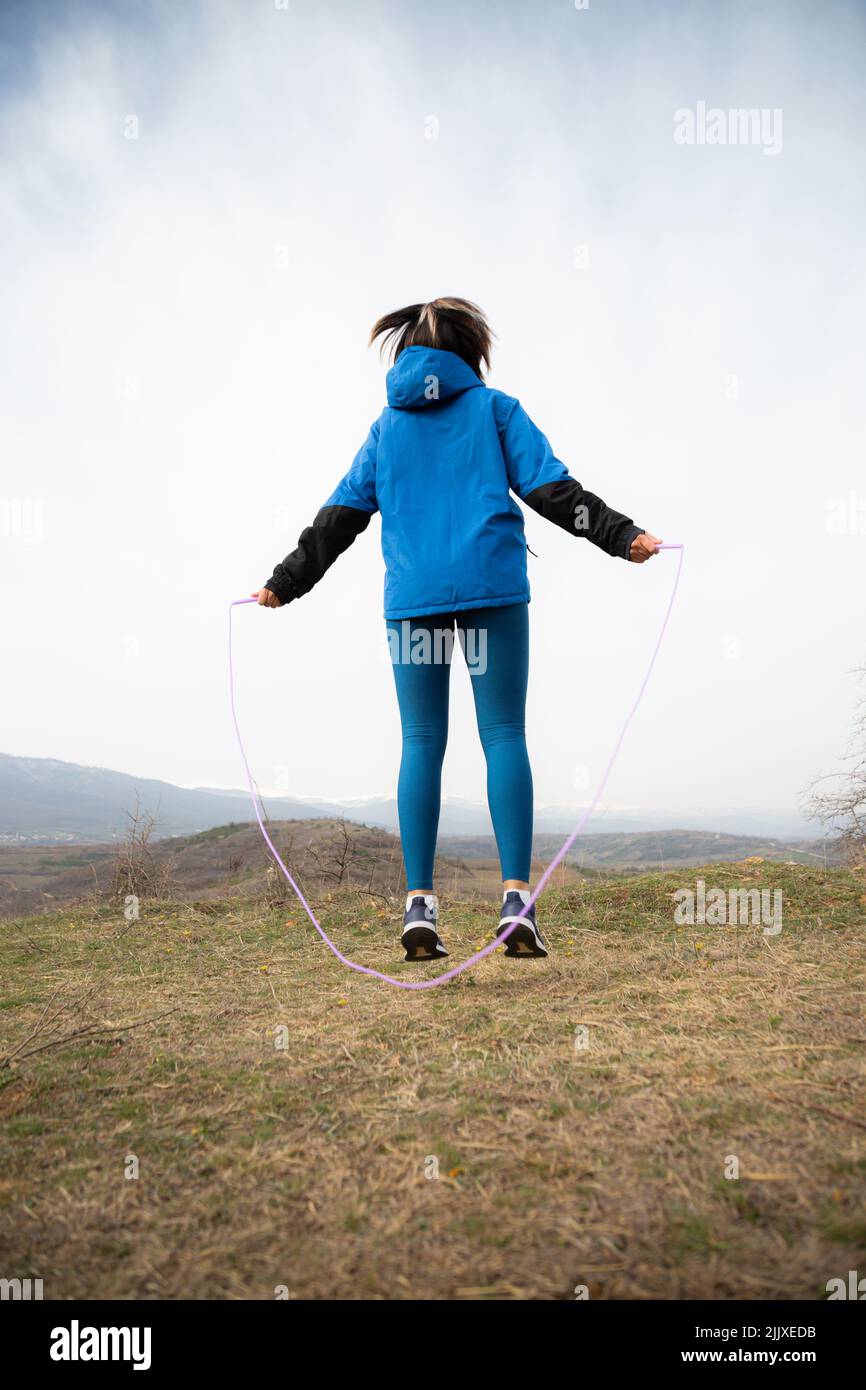 Amazing and active woman is doing a jumping rope exercise before ...