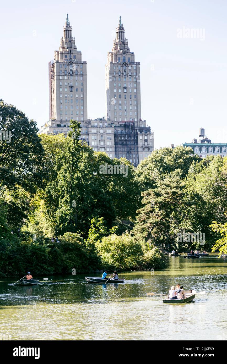 A rowboat sailing on the central park lake with the view of the ...