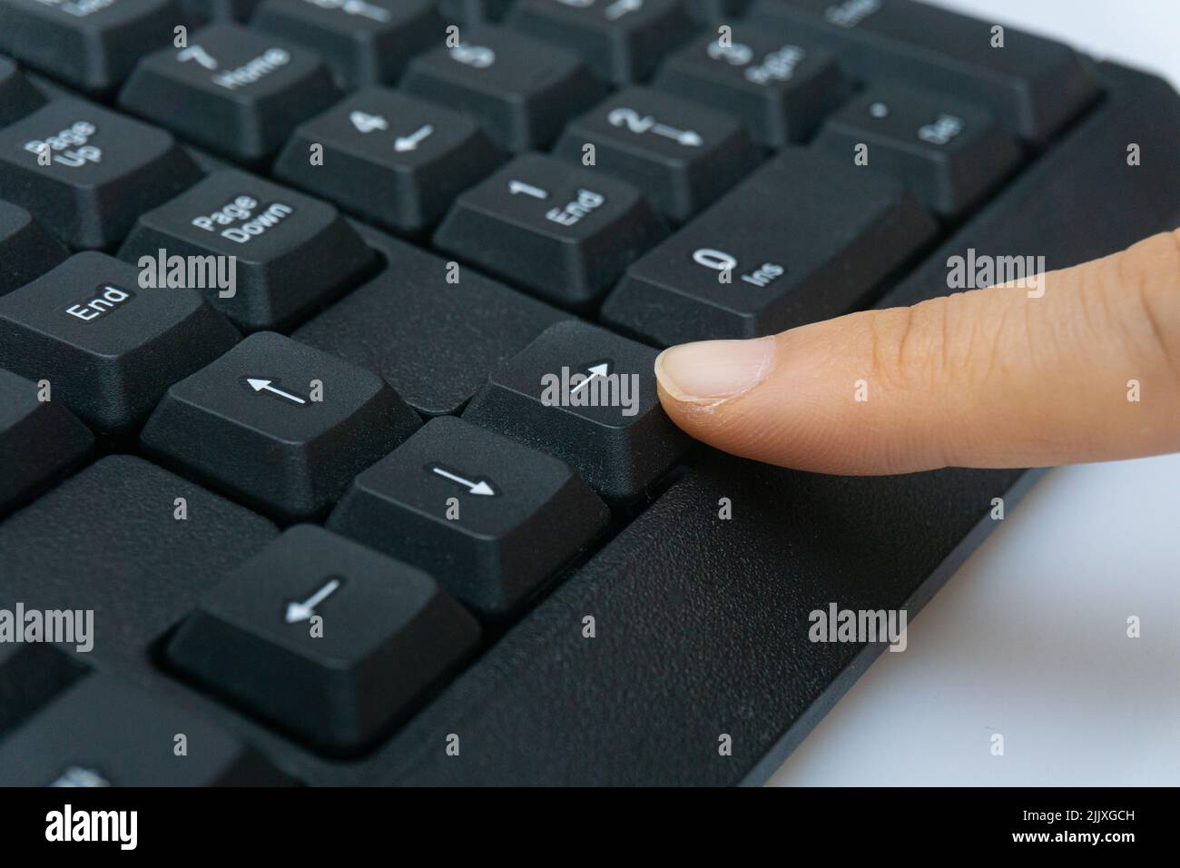 A woman's finger holding a computer keyboard Stock Photo - Alamy