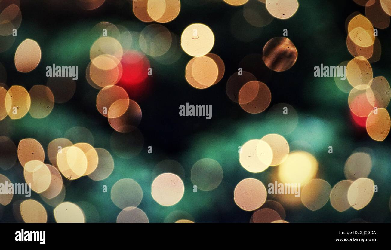 A multi-colored bokeh caused by moving blued lights in the background ...