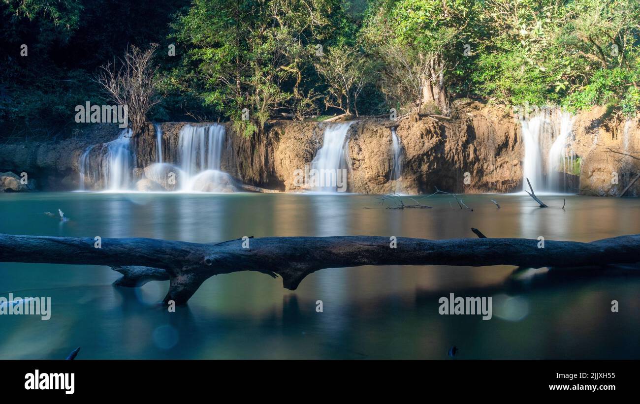 A scenic view of small waterfalls coming out of a hill into the lake in ...
