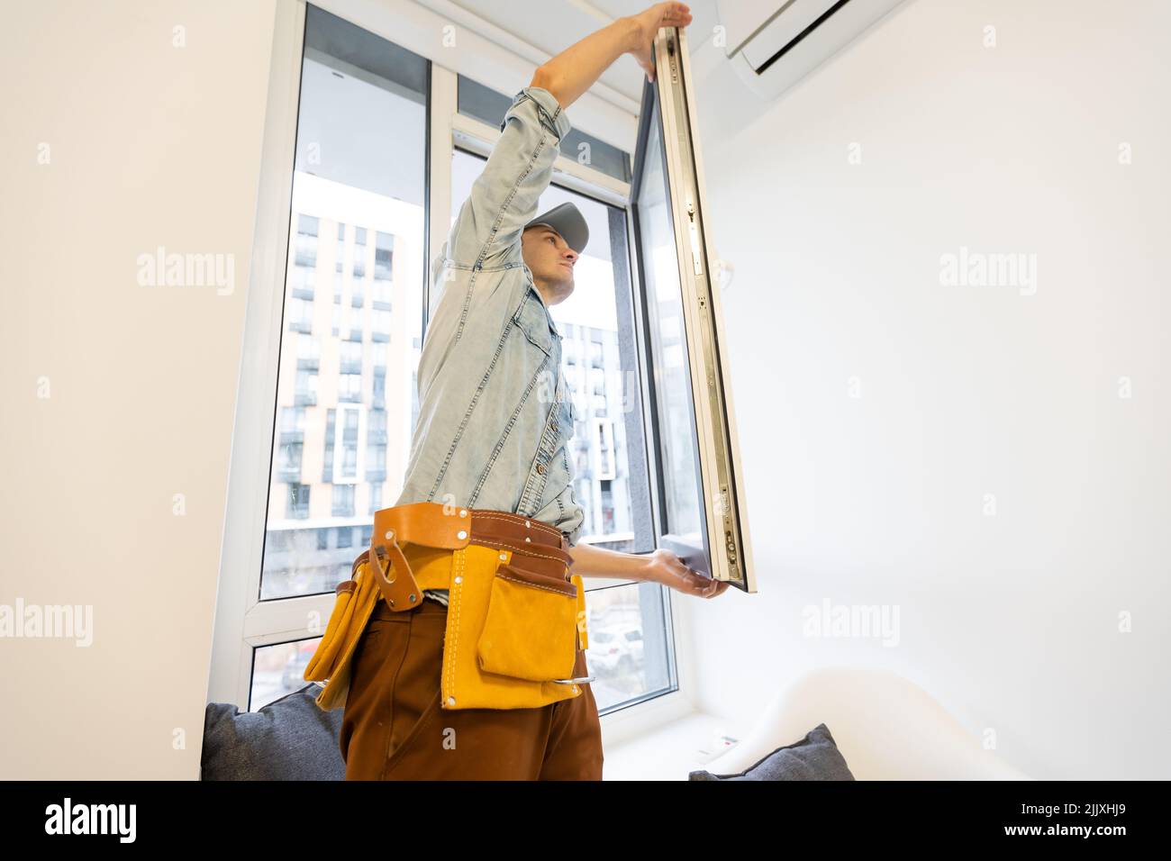 Construction worker installing window in house Stock Photo - Alamy