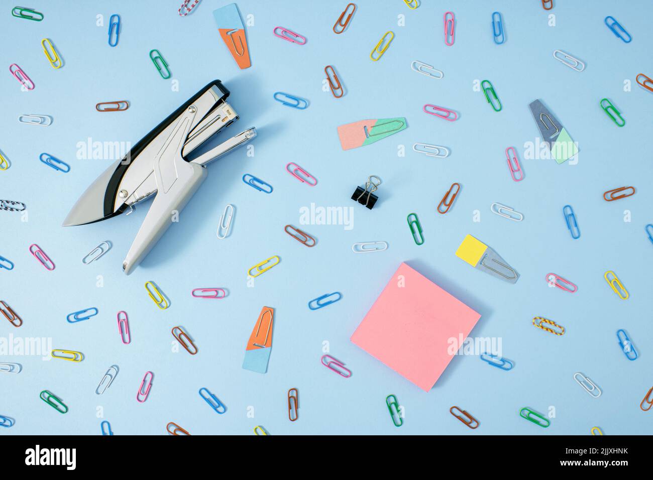 Creative office concept of multi-colored paper clips on pastel blue ...