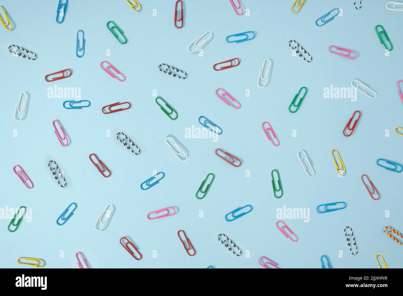 Creative office concept of multi-colored paper clips on pastel blue ...