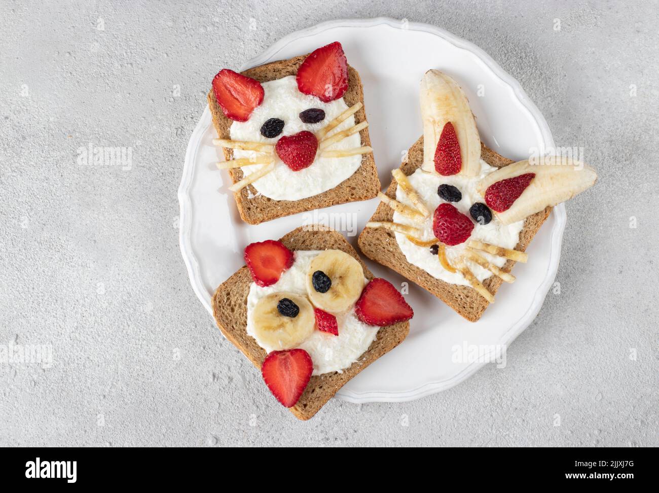 Three sweet toasts for kids in shape of cat, rabbit and chick with ...