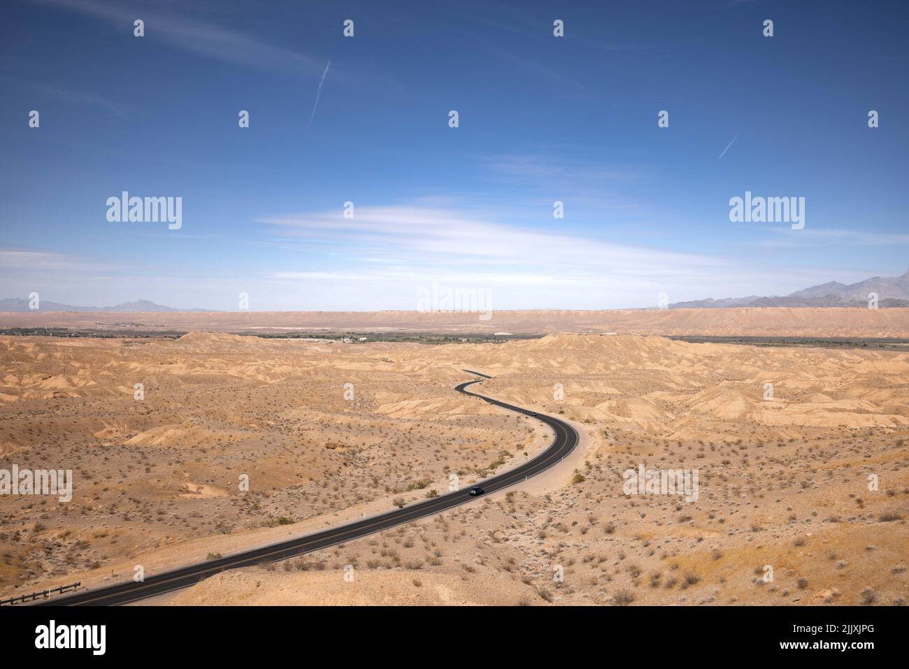 a High angle view of winding road through Badlands in a sunny day with ...