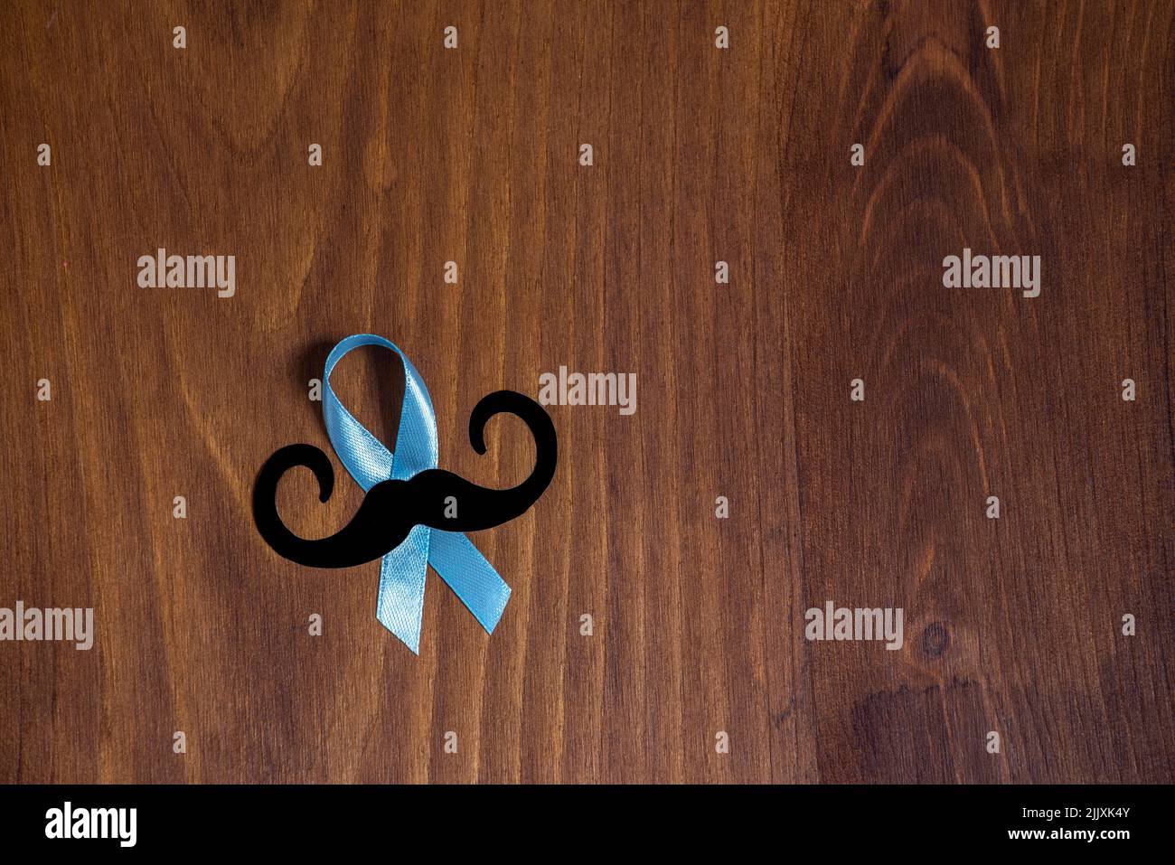 Blue prostate cancer awareness ribbon with a moustache on a rustic ...