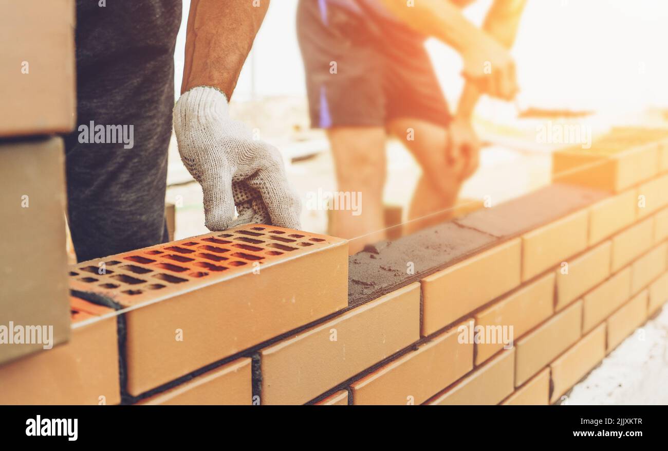 Worker or mason hands laying bricks close up. Bricklayer works at brick ...