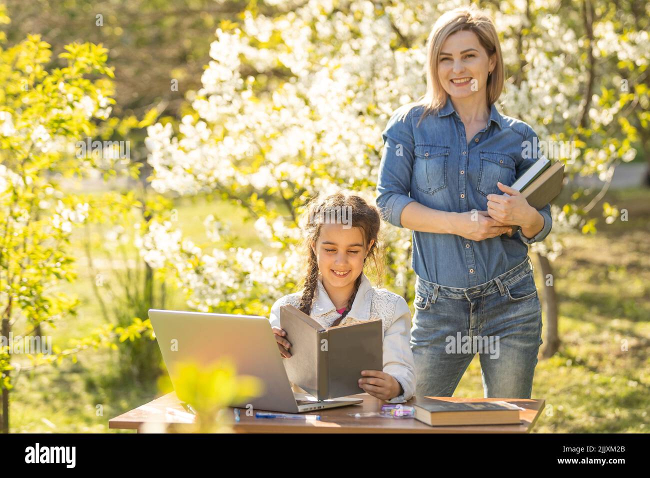 little girl with mom learning on laptop outdoor Stock Photo - Alamy